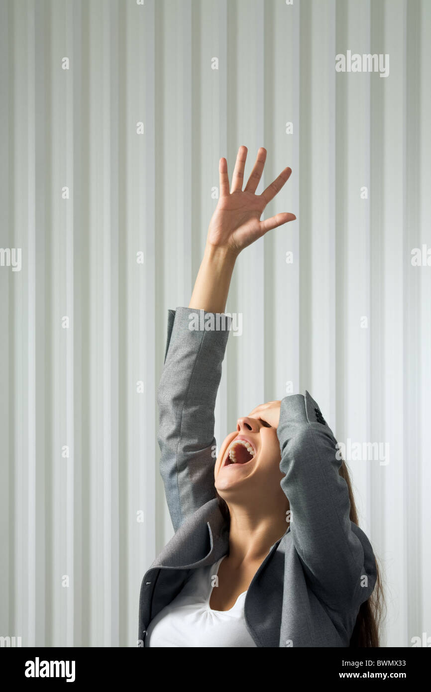 Photo of unhappy female shouting with her arm raised in pray Stock ...