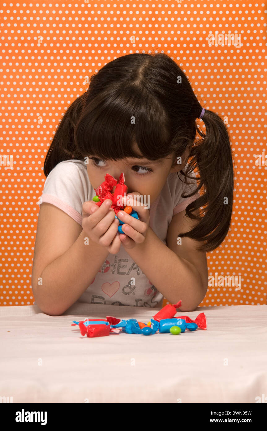 Girl smelling sweets and candies that he has in her hands Stock Photo ...