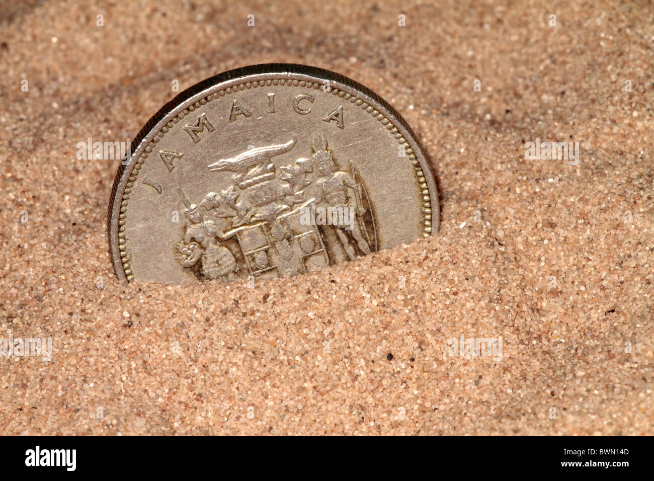 Jamaican coin in the sand Stock Photo - Alamy