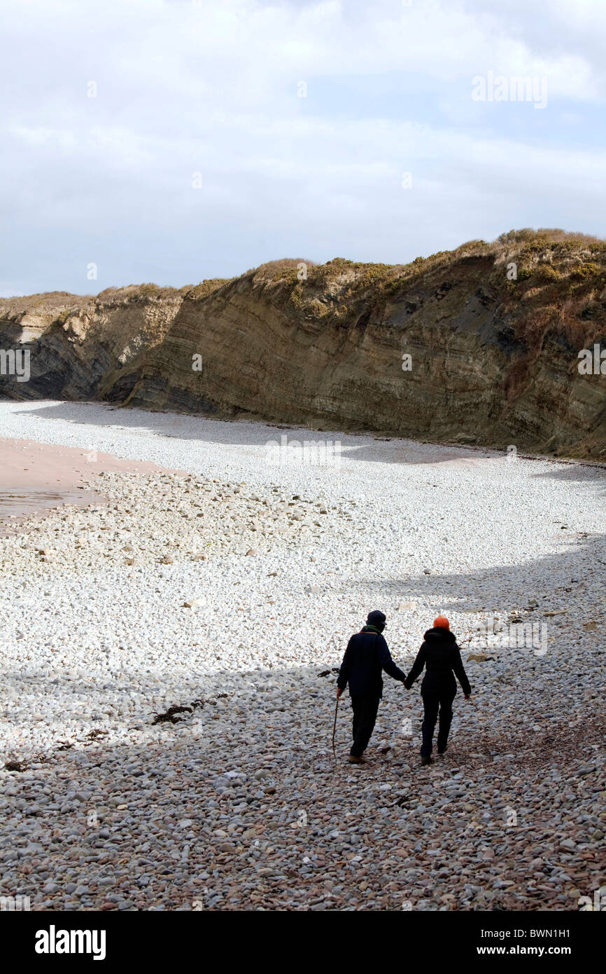 Couple walking hand in hand on Lilstock beach to visit the marine ...