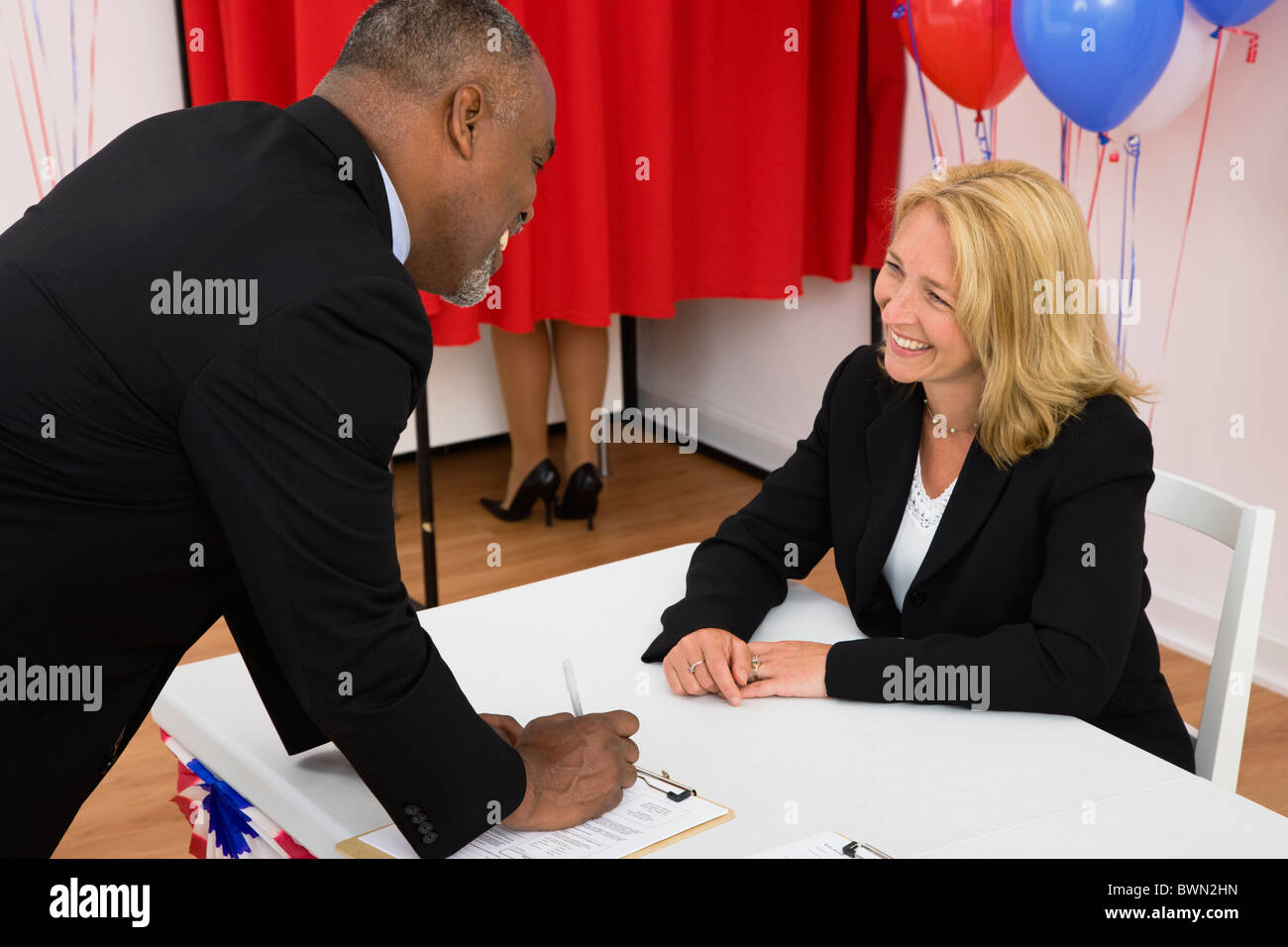 USA, Illinois, Metamora, People at polling place table, balloons and ...