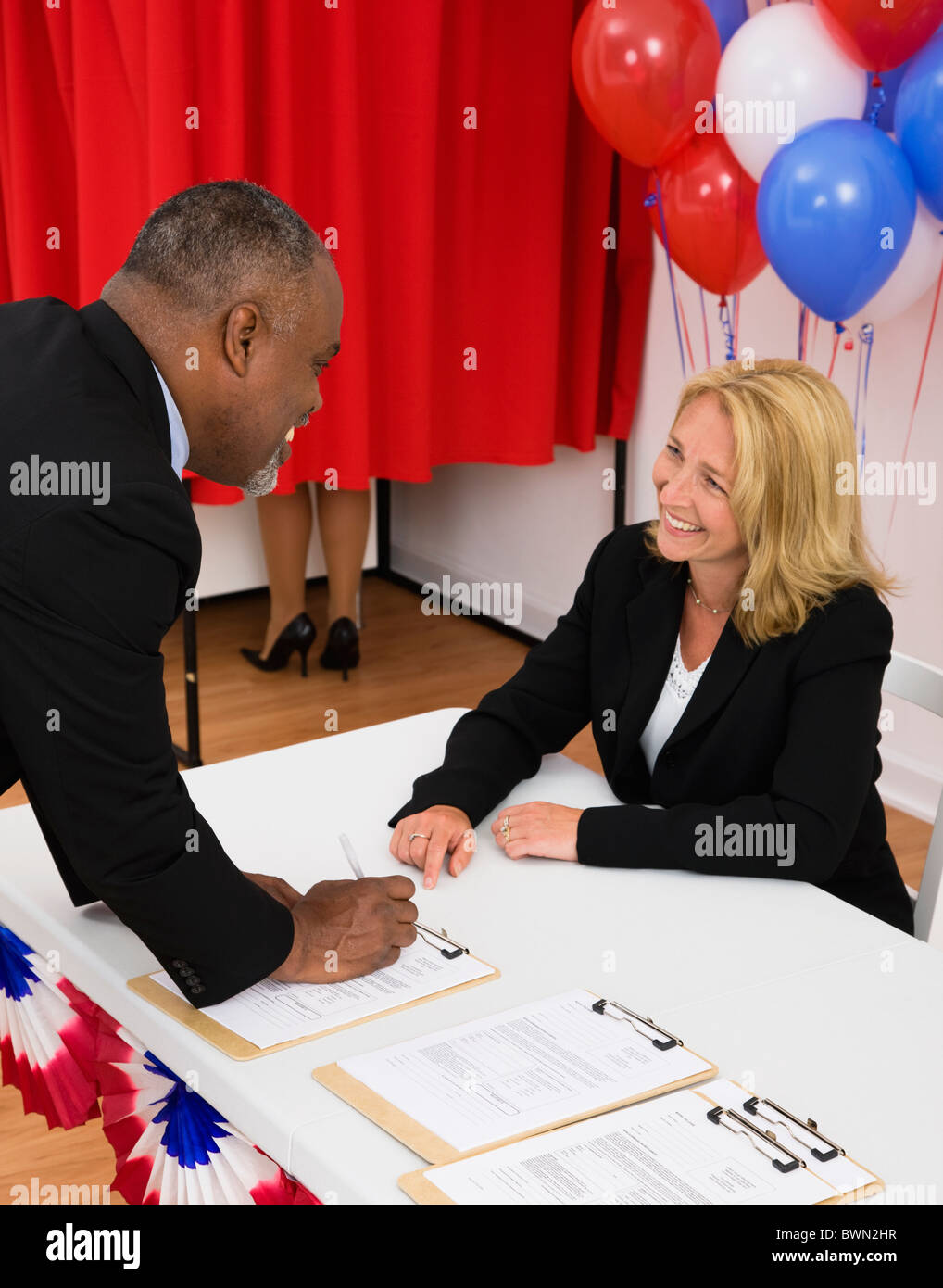 USA, Illinois, Metamora, People at polling place table, balloons and ...