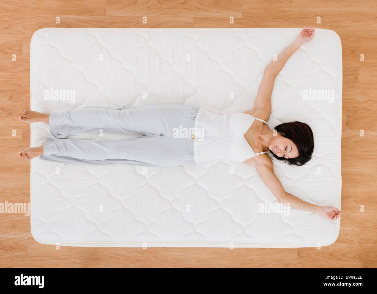 USA, Illinois, Metamora, Young woman lying on mattress and smiling ...