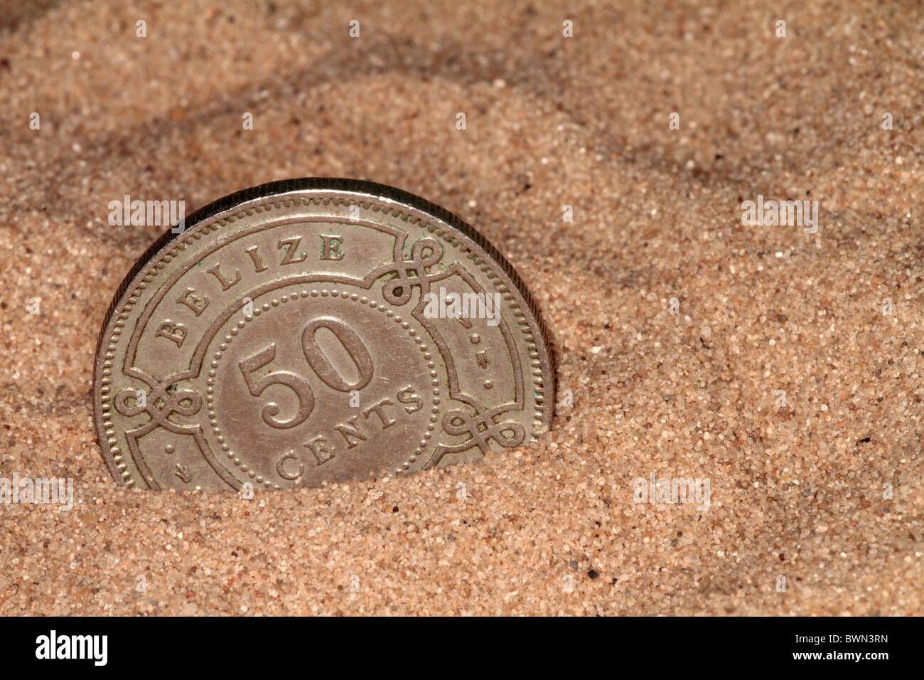 Belize coin in the sand Stock Photo - Alamy