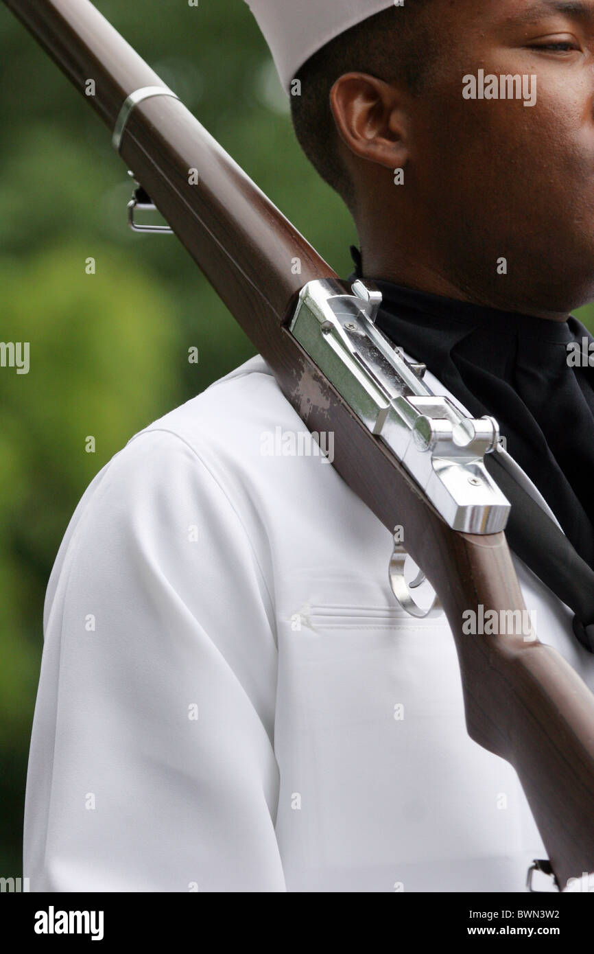 An Black African American man in the Navy marching in a parade with a ...