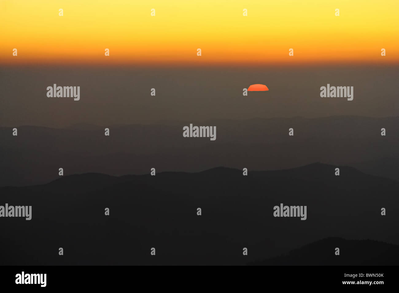 The sun rises from behind the mountains Stock Photo - Alamy