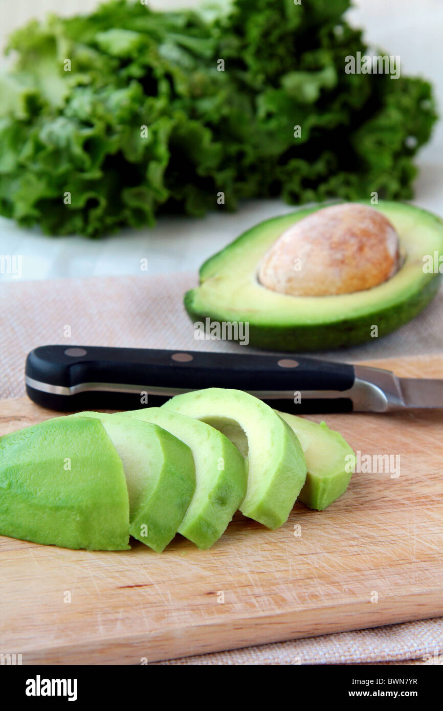 ripe peeled avocado sliced on the board Stock Photo - Alamy