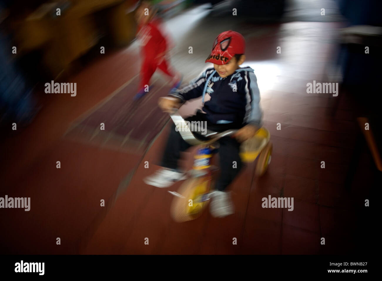 A boy rides a tricycle in a shelter for chronically ill children in ...