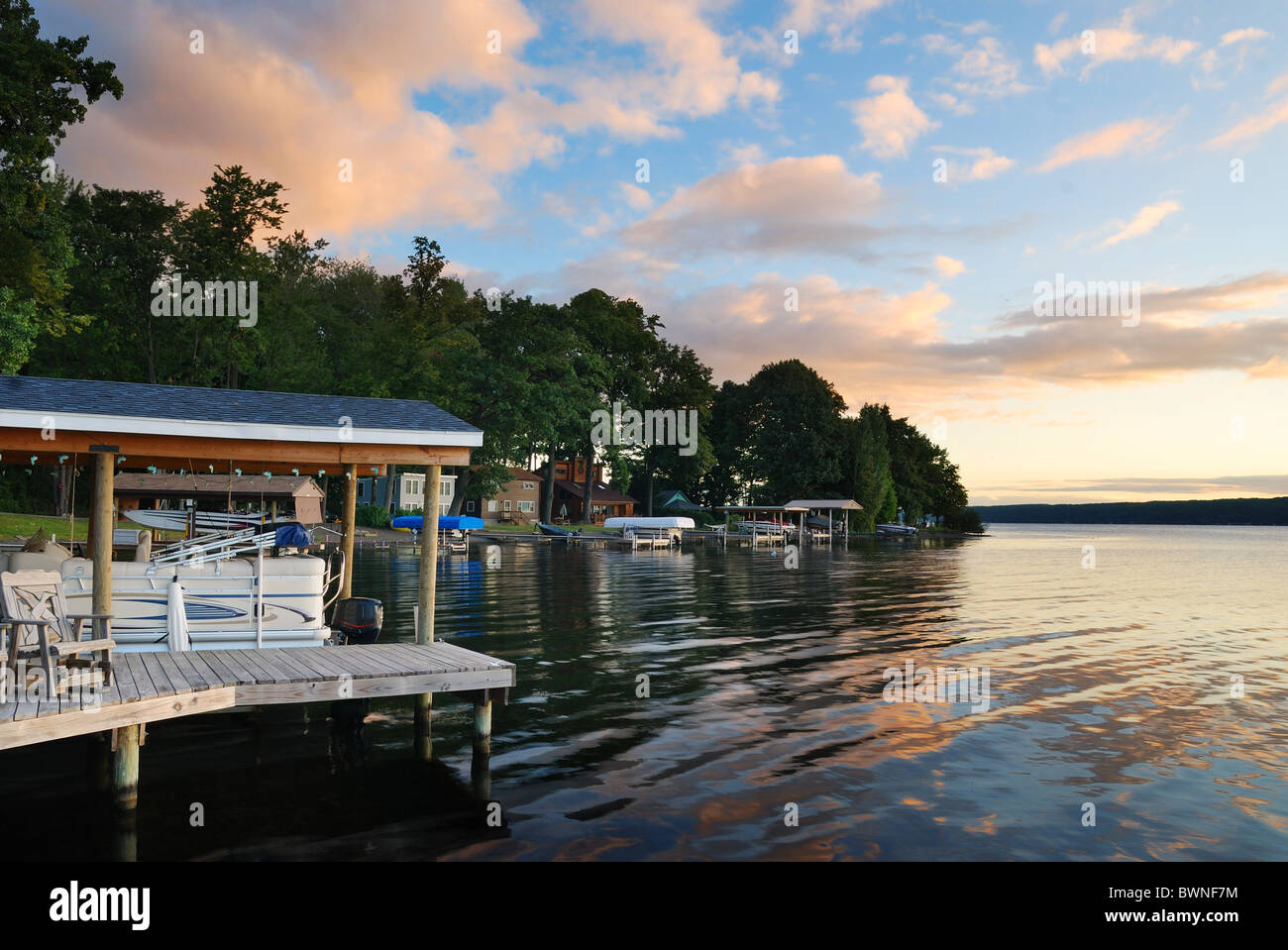 Lake house with pier and woods with sunrise in the morning in New York ...