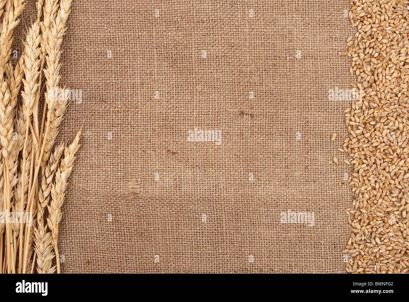 Wheat ears border on burlap background Stock Photo - Alamy