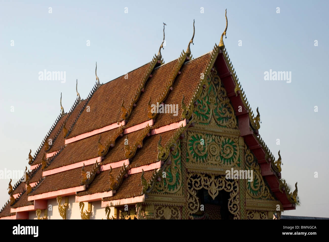 A bright Buddhist temple decorated with ornate designs is part of the ...