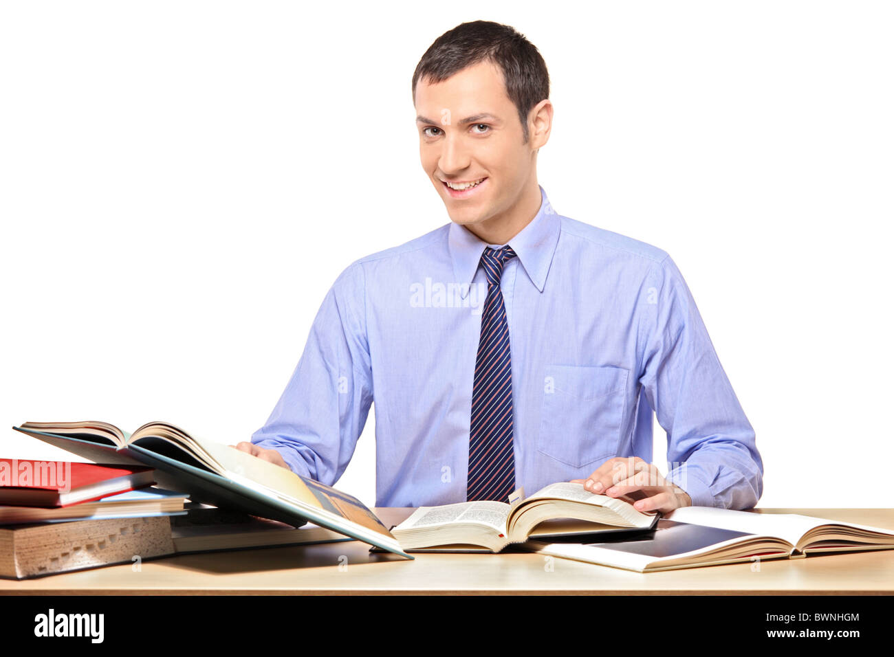 A happy man reading a book, with many other books on the desk Stock ...