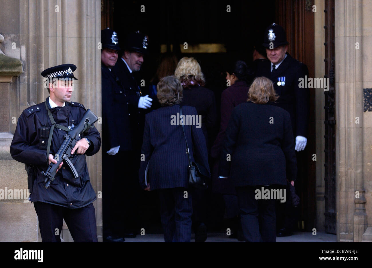 Armed policemen with guns stand guard while checks are made by the ...
