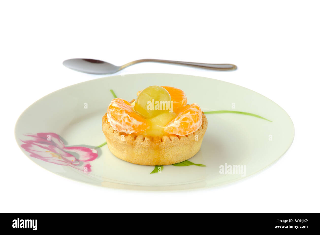 closeup view of fruits flan with mandarin and grape on a round plate ...