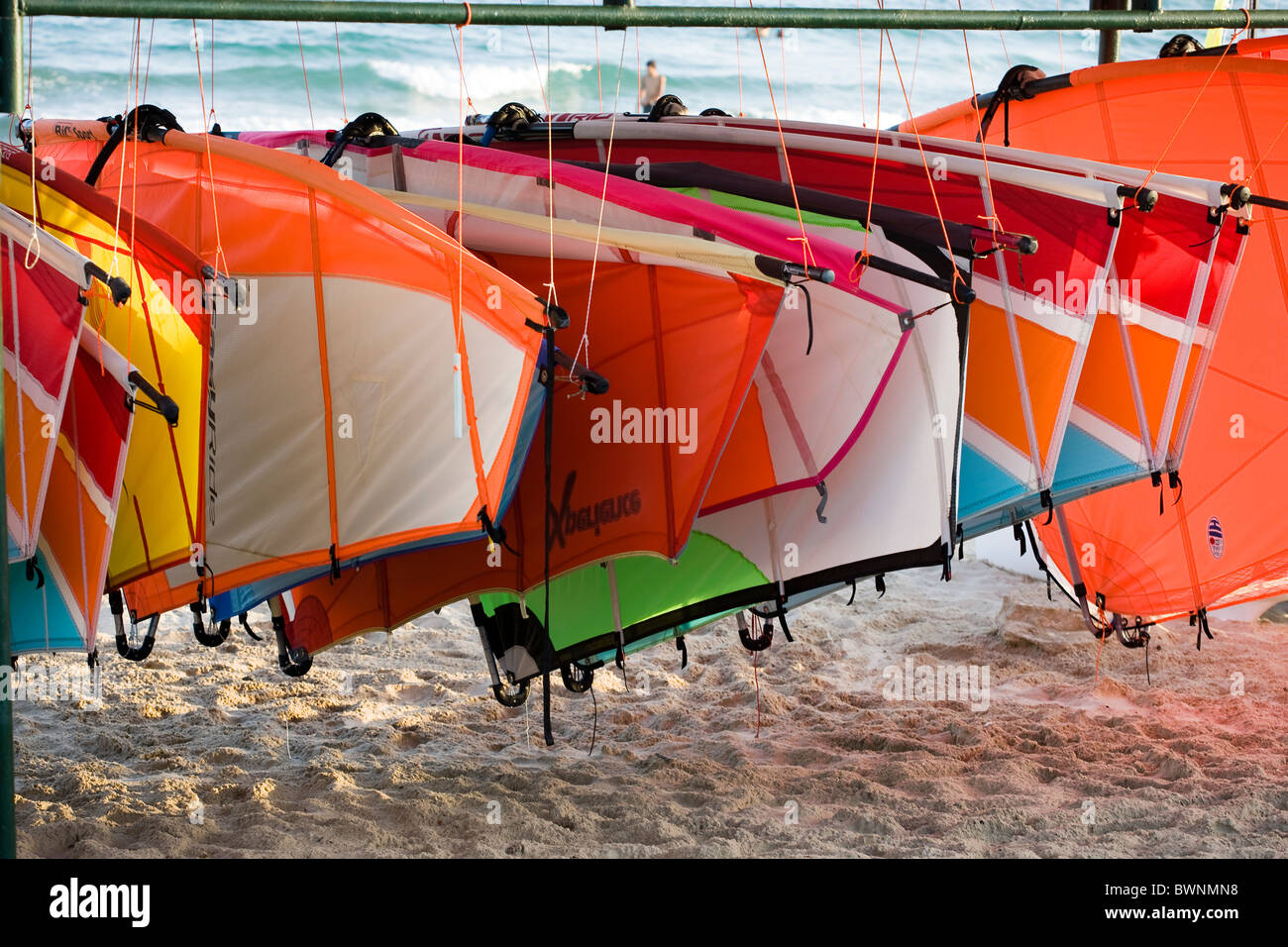 windsurf sails hanging up on a sandy beach and sea behind Stock Photo ...