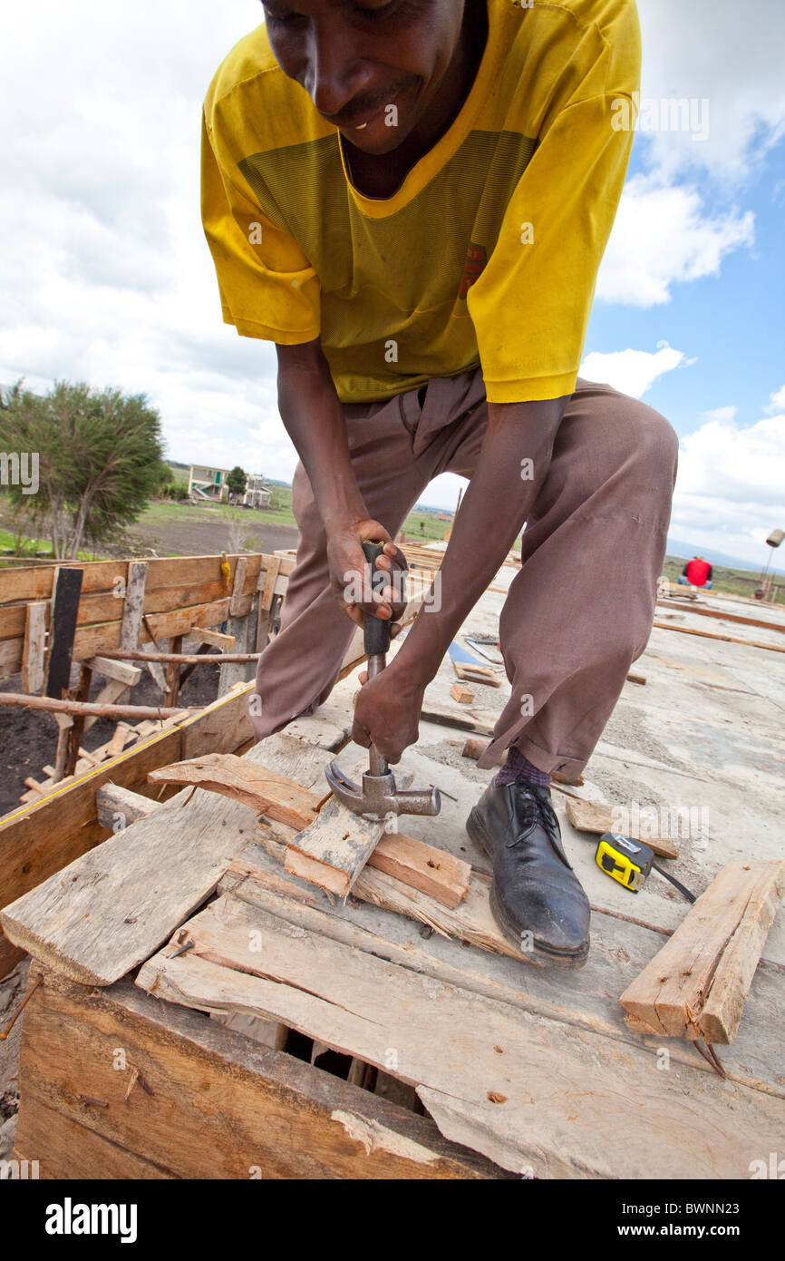 Workman helping construct a building at Maji Mazuir Centre and School ...