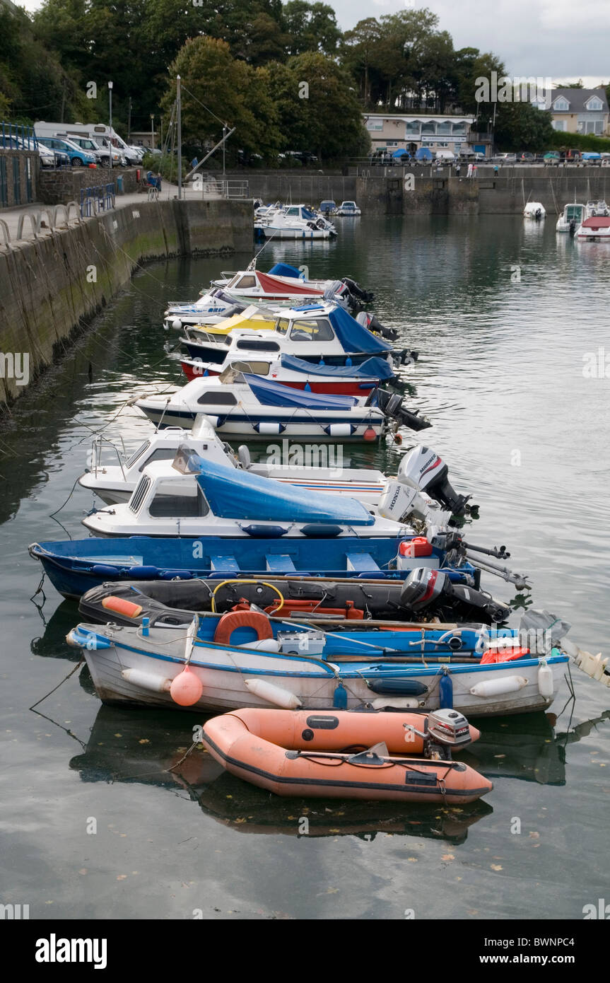 Brightly coloured boats moored in a row at Saundersfoot harbour in ...