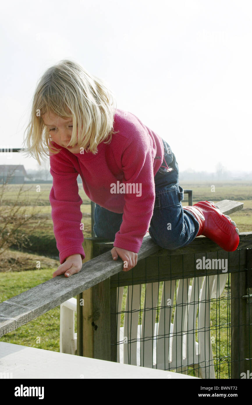 Toddler climbing over fence Stock Photo - Alamy