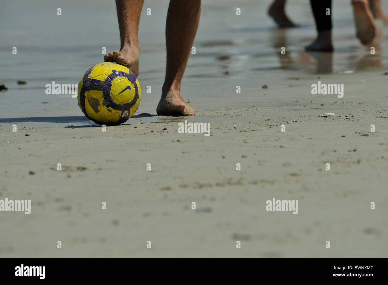 Foot of man on colourful soccer ball playing beach football Concepts ...