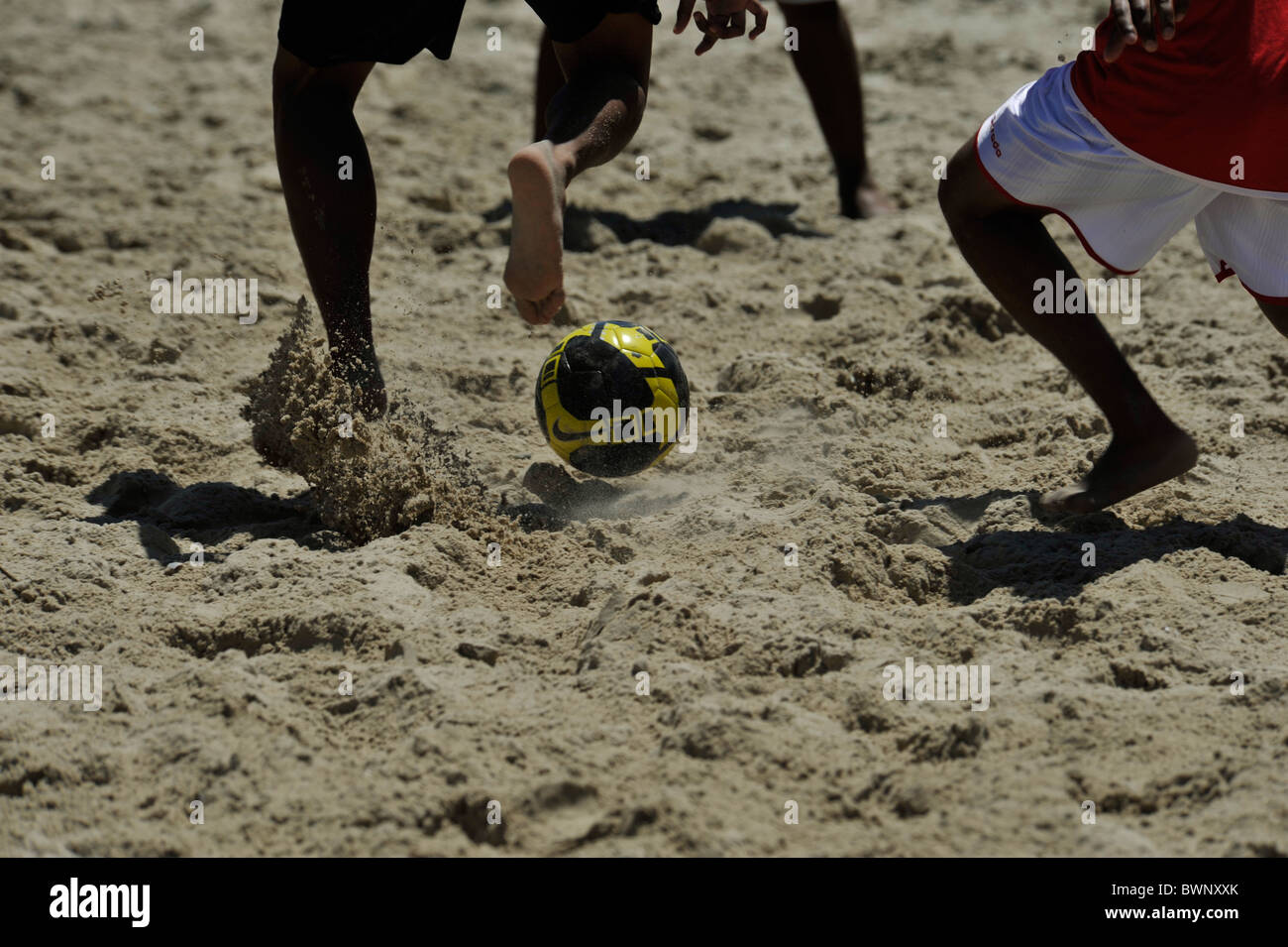 Feet of Soccer players competing for ball playing Football on beach ...