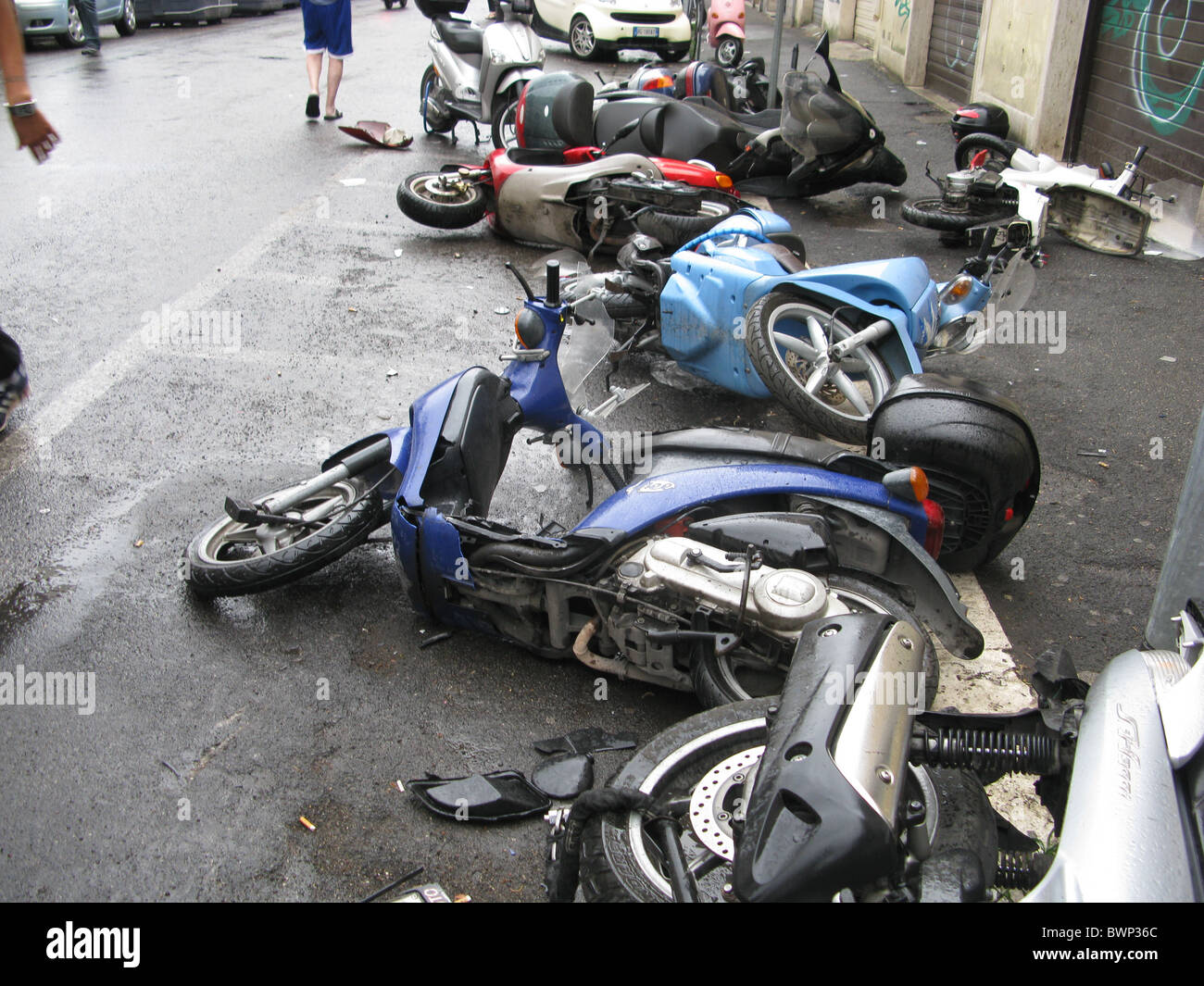 row of scooters damaged by a hit and run driver, rome Stock Photo - Alamy