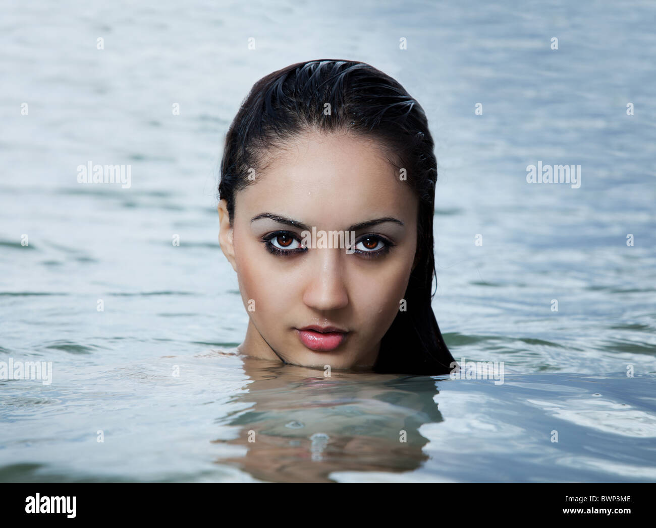 The beautiful Asian girl model poses in water, sits on a neck in water ...