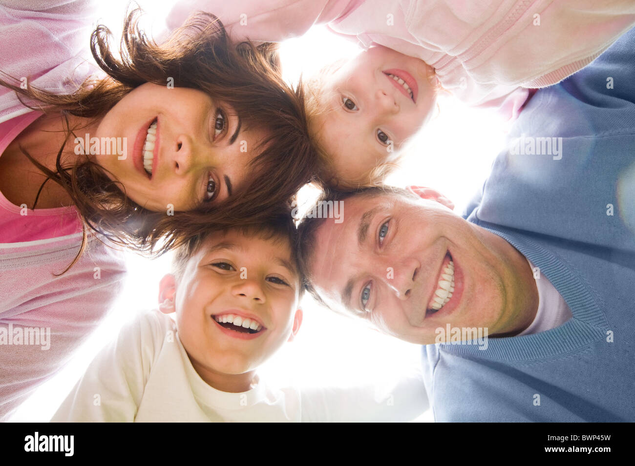 Below view of family members head by head smiling at camera Stock Photo ...