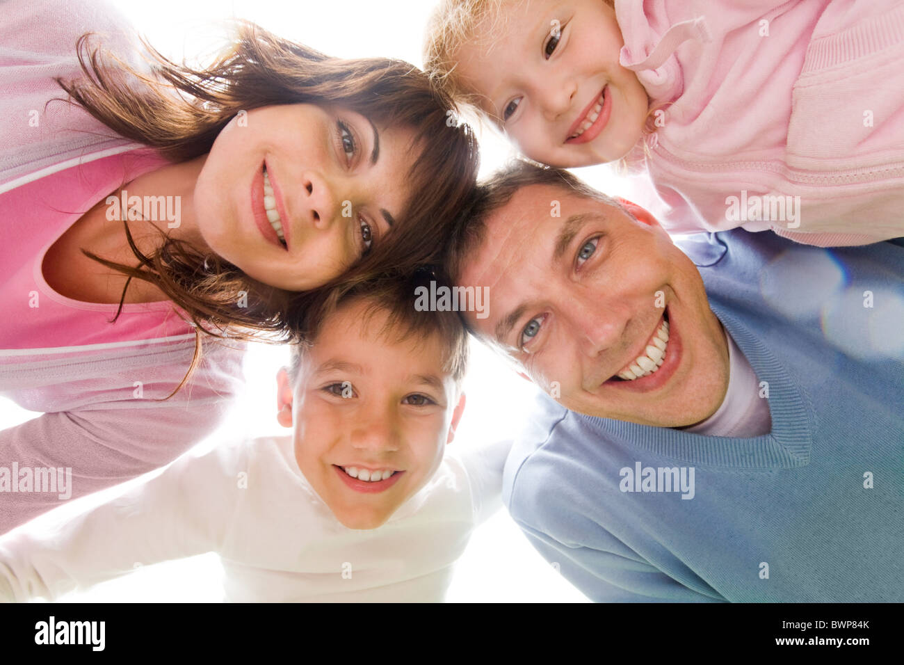 Below view of family looking at camera against light sky Stock Photo ...