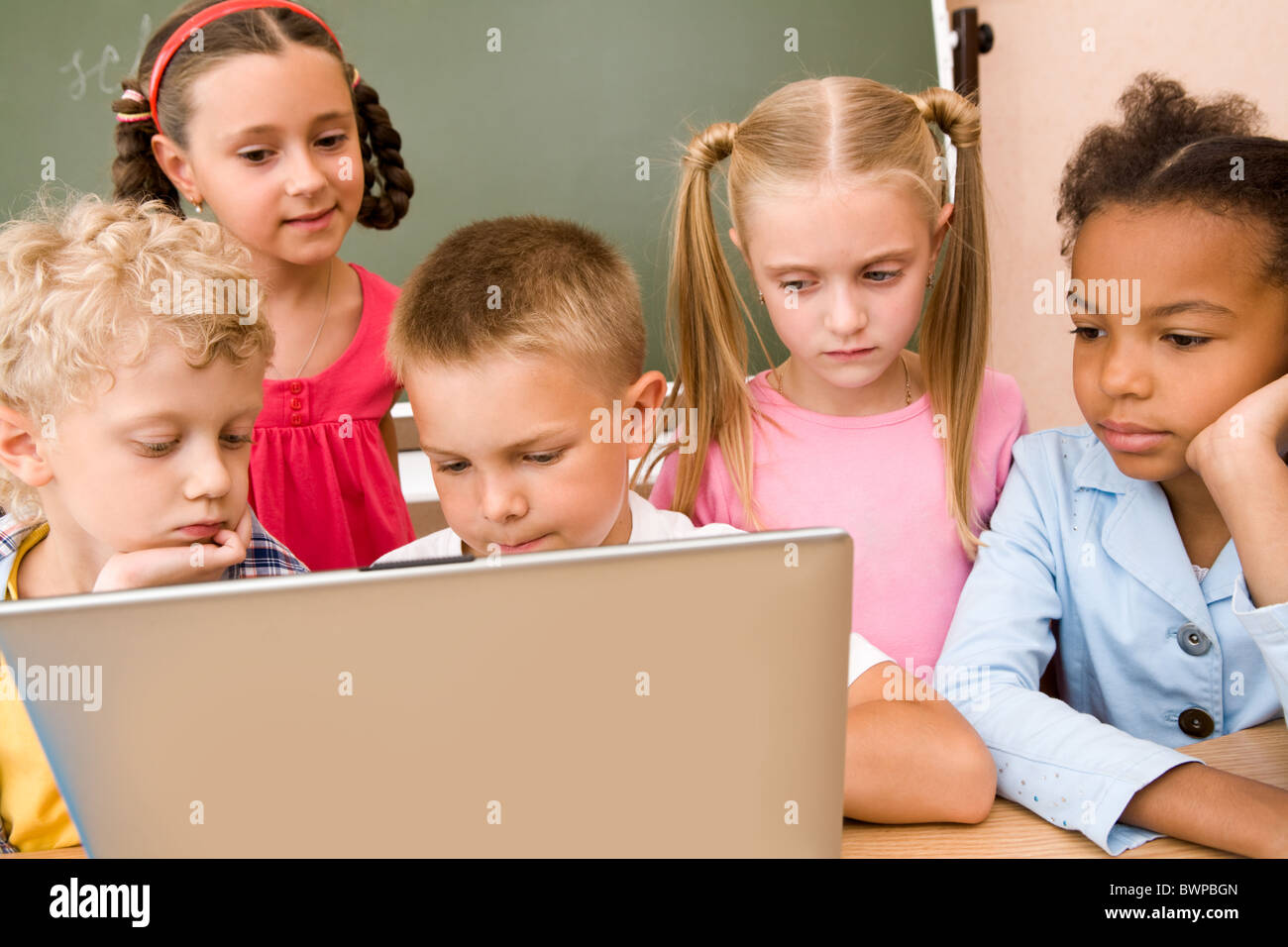 Portrait of serious kids working with laptop during lesson Stock Photo ...