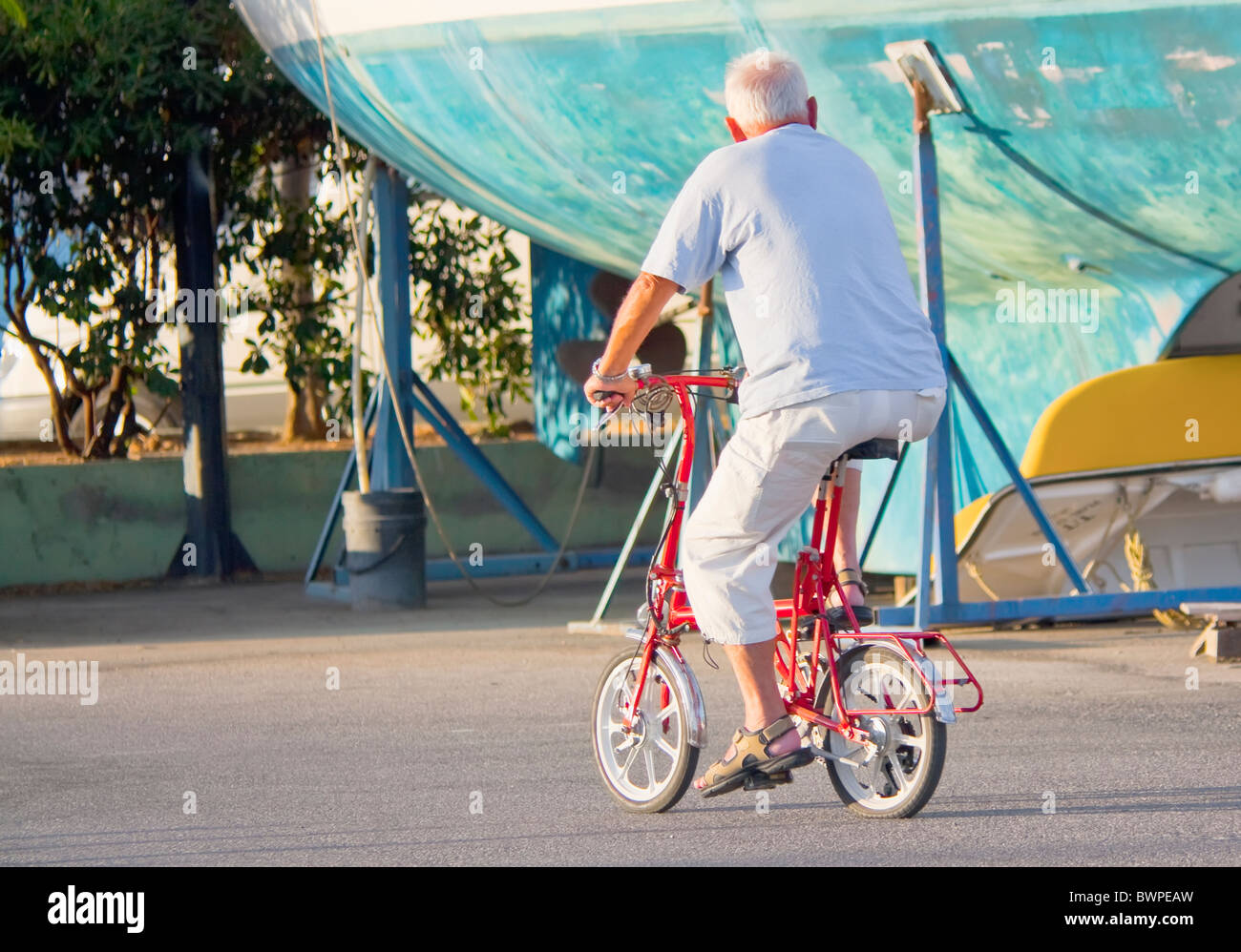 Elderly man riding a mini bicycle Stock Photo - Alamy