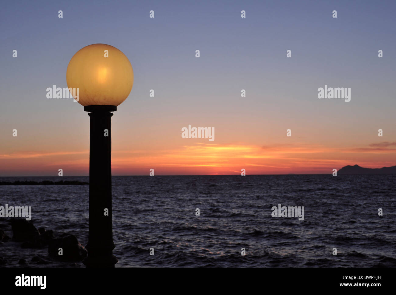 lamp post at sunset in front of the sea Stock Photo - Alamy