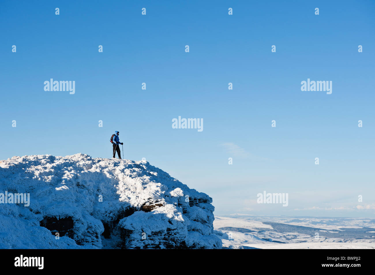 Female hiker stands on summit of Corn Du in winter, Brecon Beacons ...