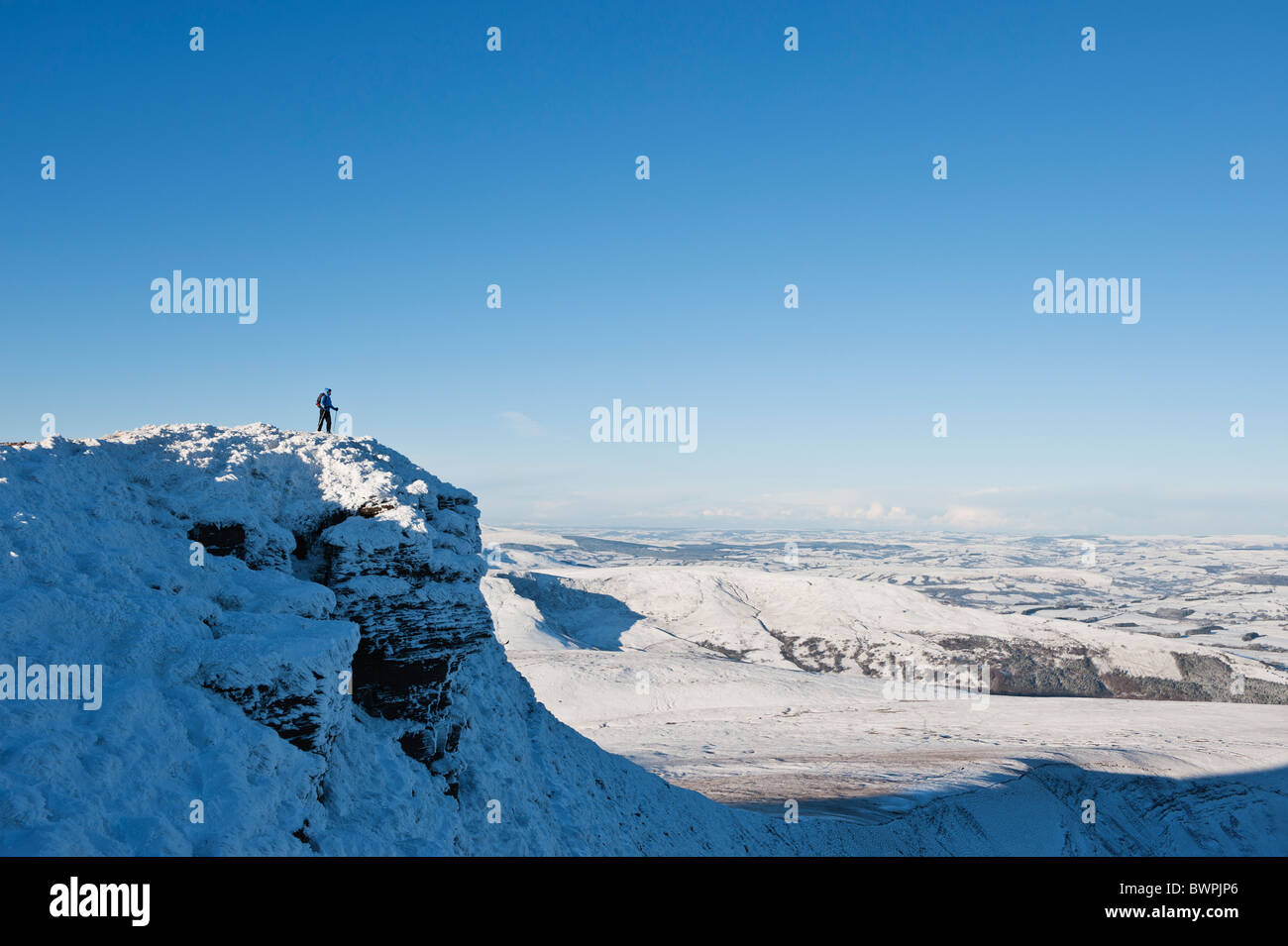 Female hiker stands on summit of Corn Du in winter, Brecon Beacons ...