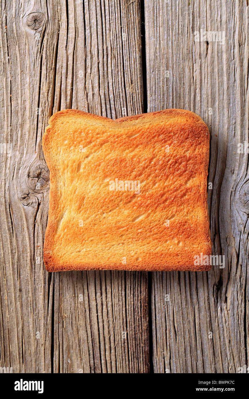 Slice of toasted bread on rough wood Stock Photo - Alamy