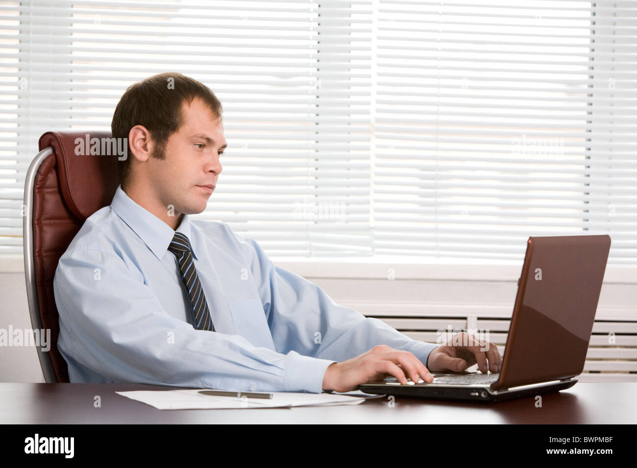 Photo of pensive boss looking at laptop screen while working in office ...