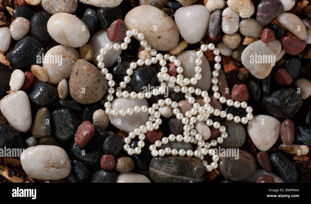 String of pearls, laid on a pile of river rocks Stock Photo - Alamy
