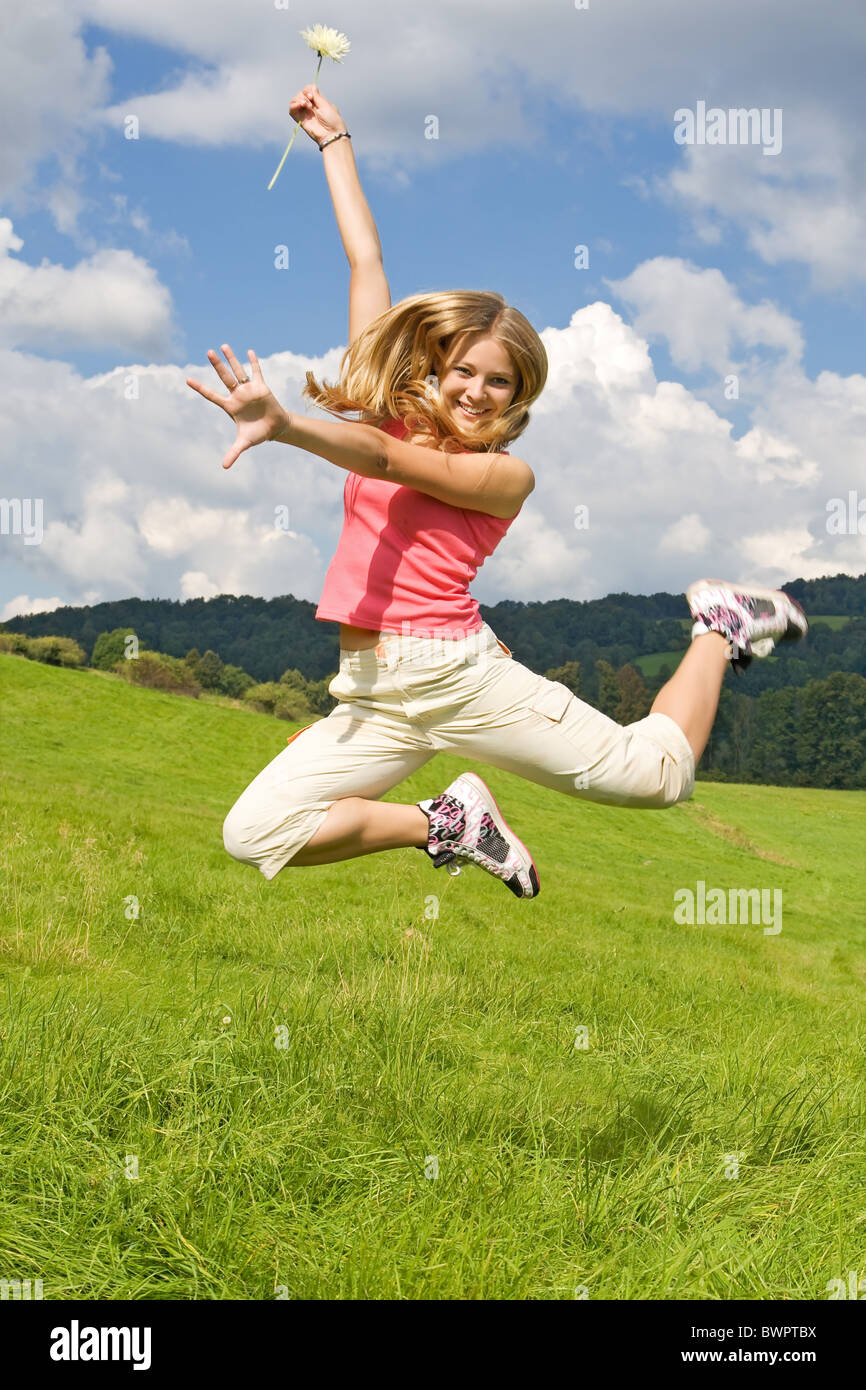 beautiful girl with flower jump on meadow Stock Photo - Alamy
