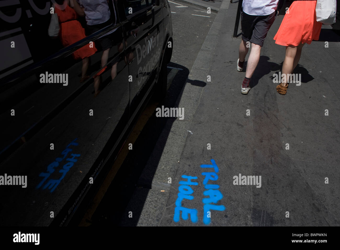 Blue stencilled painted words saying "trial Hole" seen on London street ...