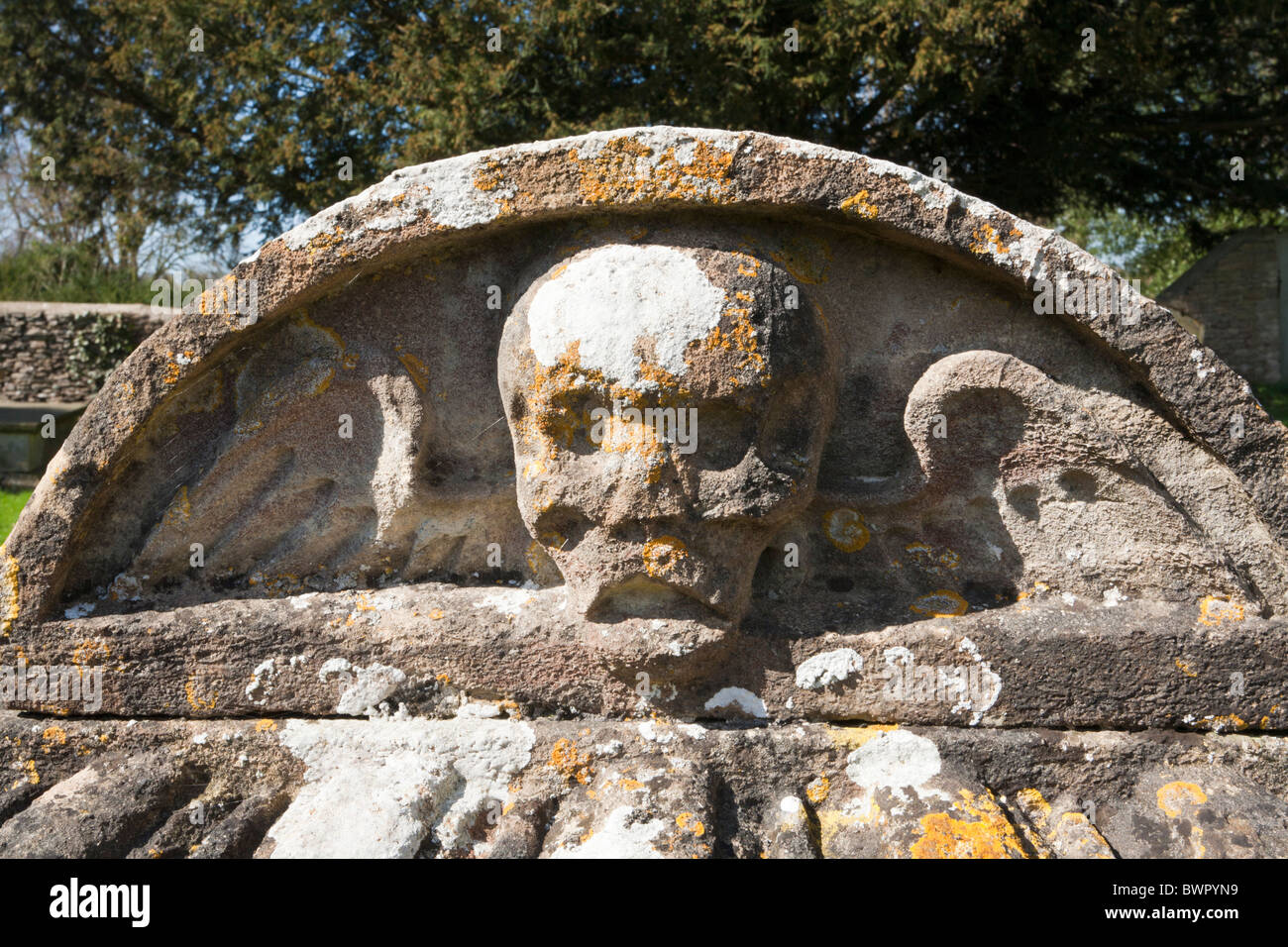A winged skull on a gravestone in the Cotswold churchyard at Fairford ...