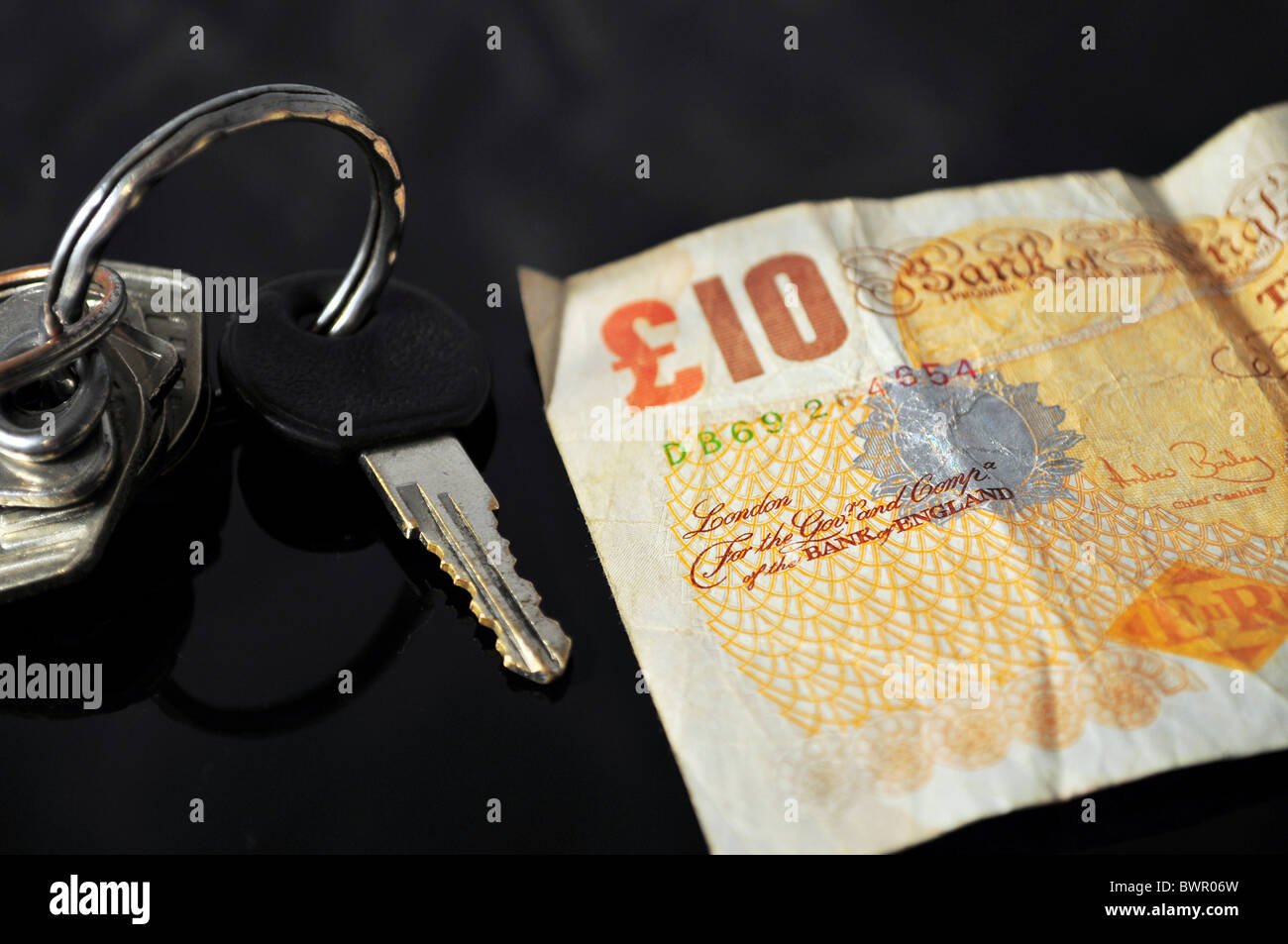 A set of keys alongside a ten pound note Stock Photo - Alamy