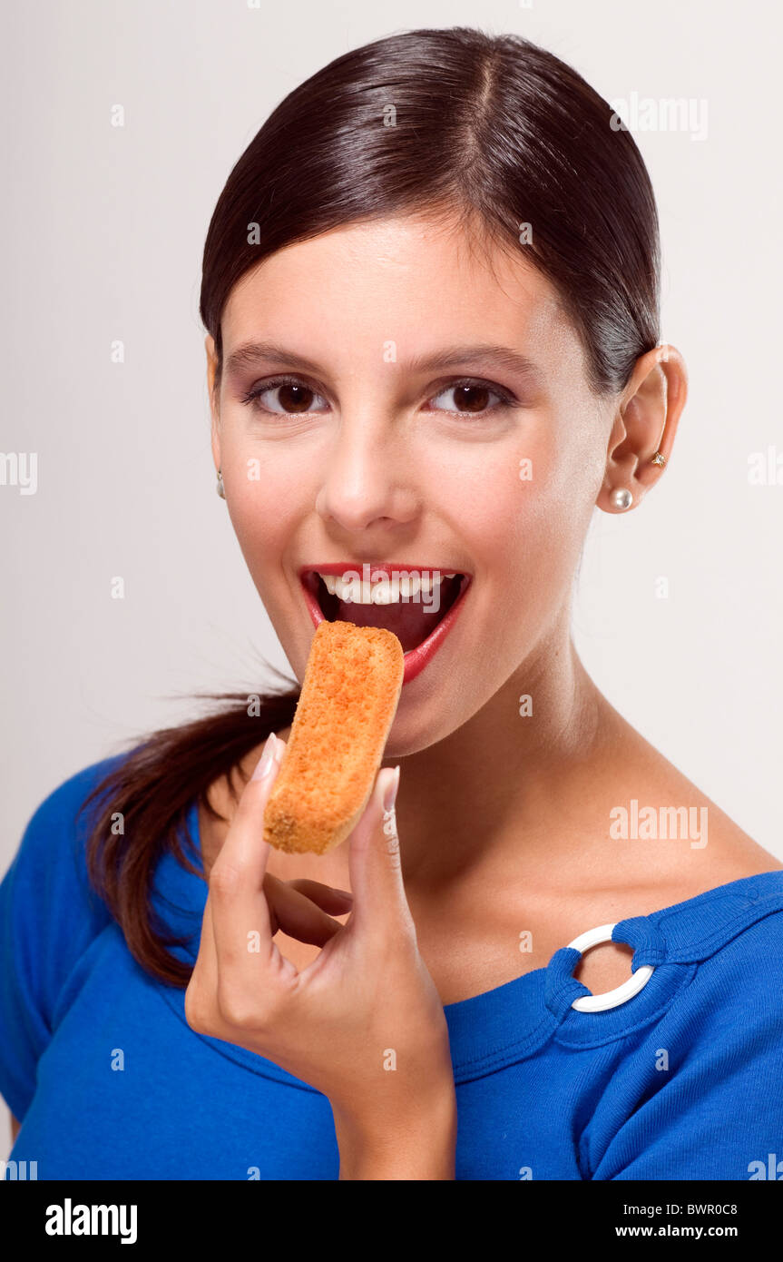 Portrait of a young women eating a biscuit Stock Photo - Alamy