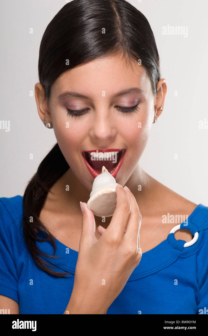 Portrait of a young women eating white chocolate Stock Photo - Alamy