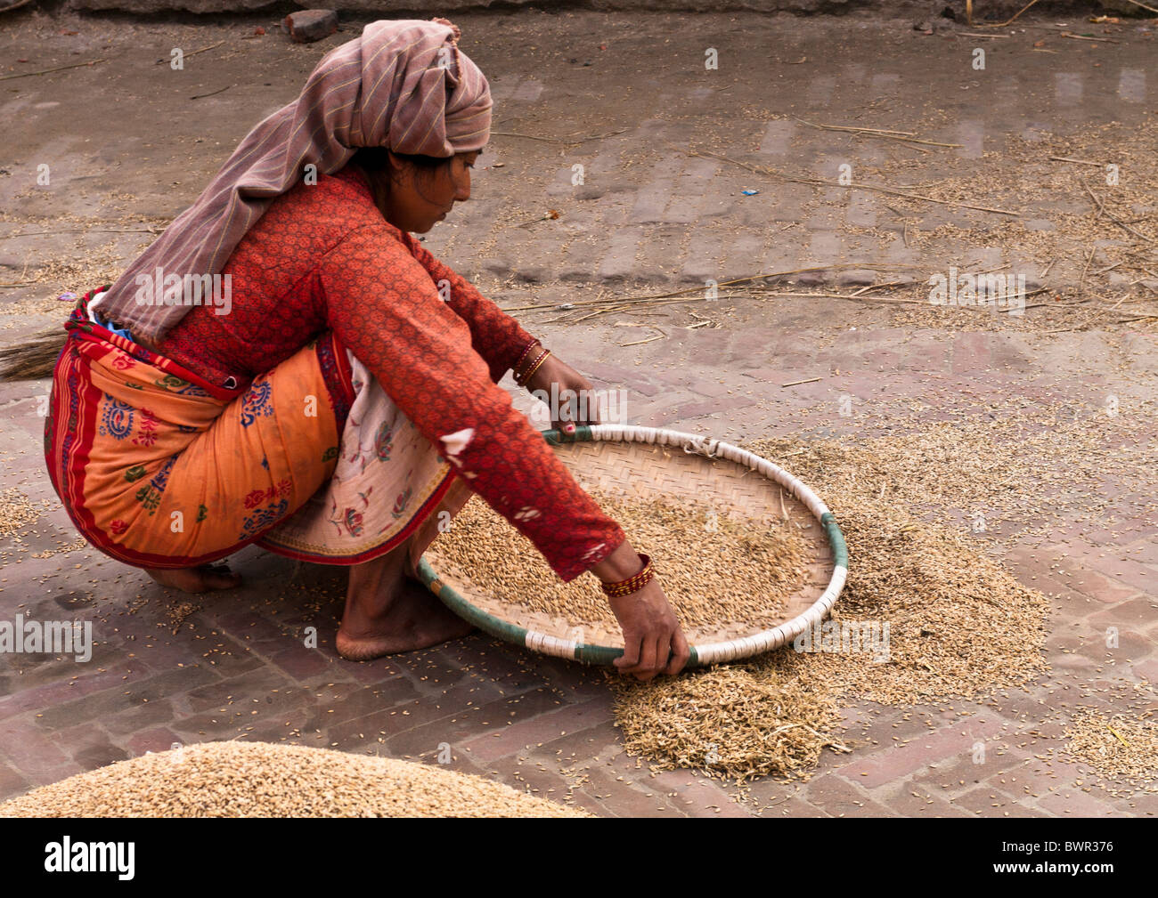 Lady sieving rice, Bhaktapur, Nepal Stock Photo - Alamy