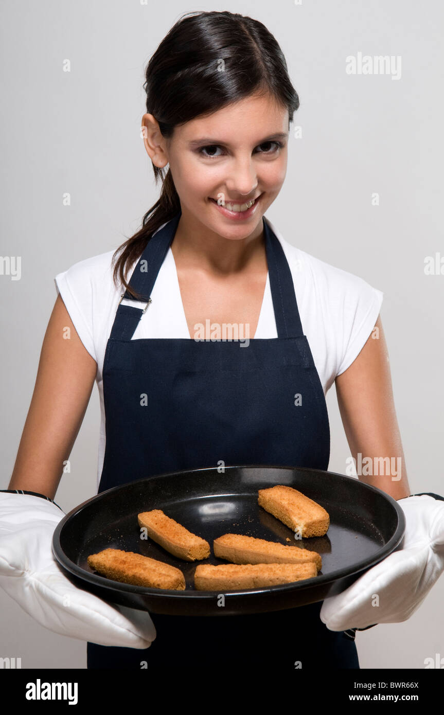 Portrait of a waitress with a baking tray with biscuits Stock Photo - Alamy