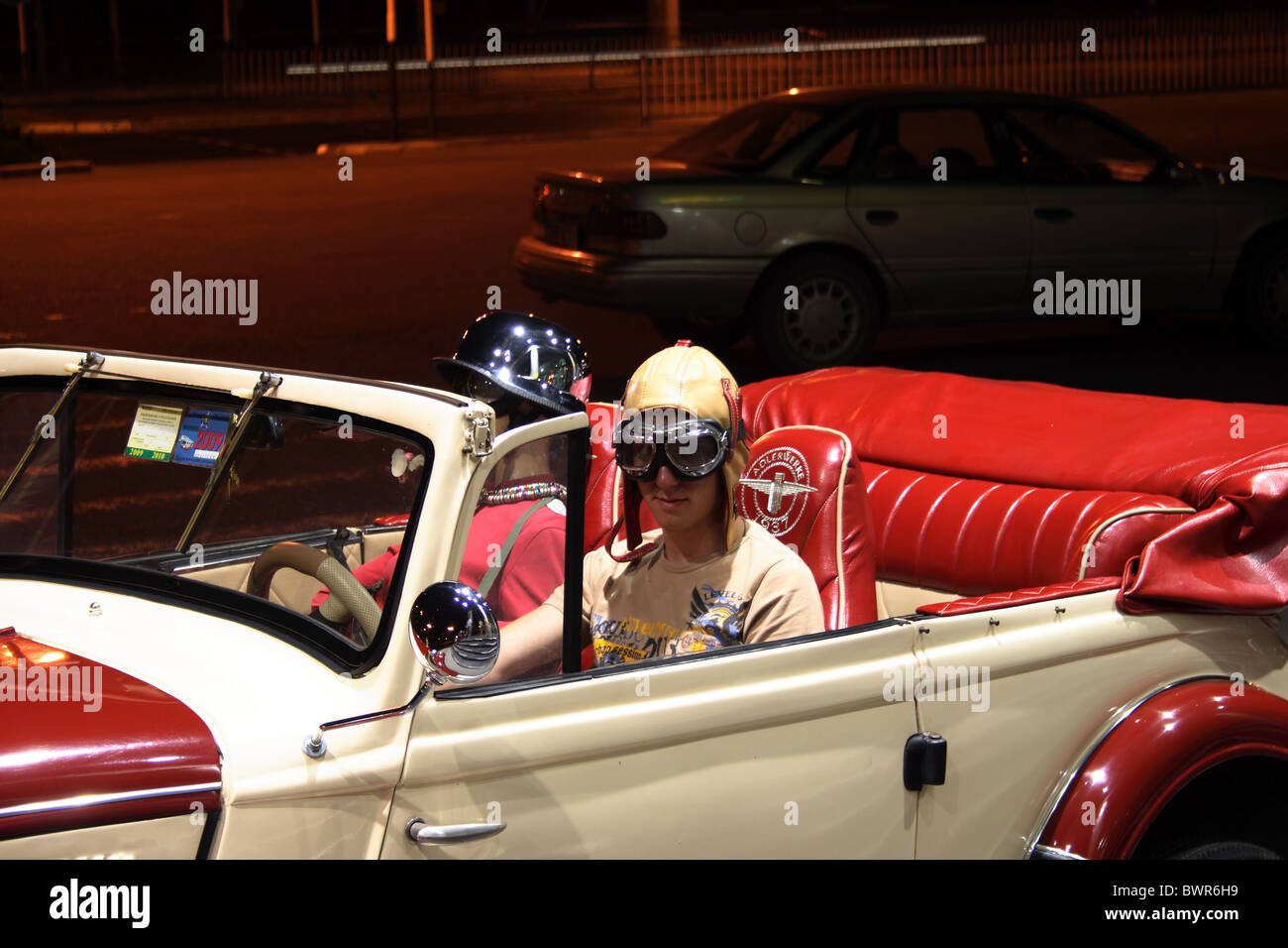 Young man driving by restored classic German car manufactured by Adler ...