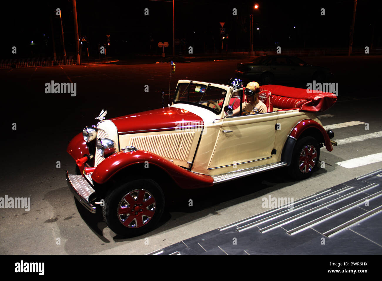 Young man driving by restored classic German car manufactured by Adler ...