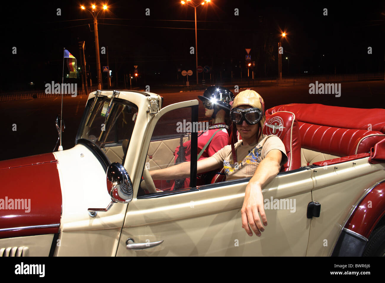 Young man driving by restored classic German car manufactured by Adler ...