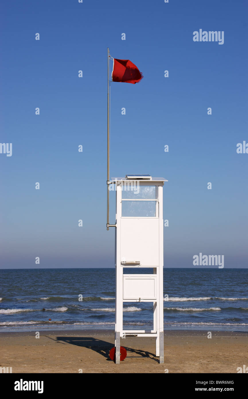 Lifeguard tower on the beach with a red warning flag Stock Photo - Alamy