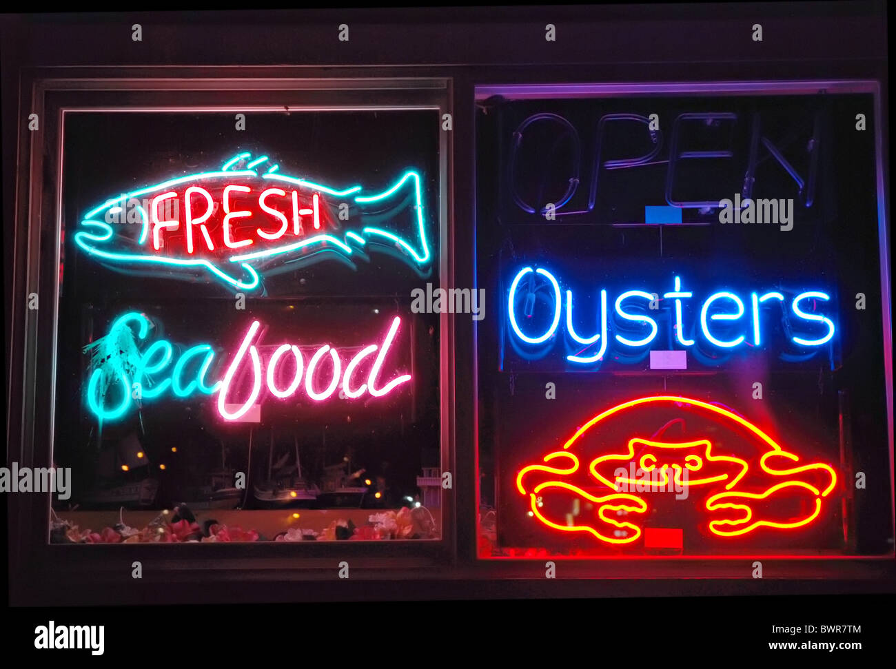 Nighttime window filled with a variety of seafood neon signs Stock ...