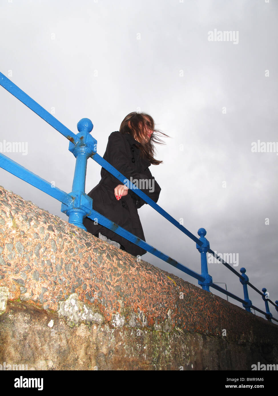 Young teen girl looking and leaning out over railing Stock Photo - Alamy